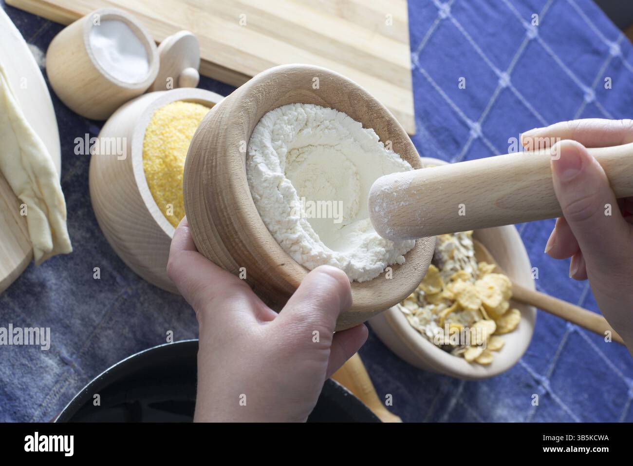 Female hand holding mortar and pestle with wheat flour All around ...