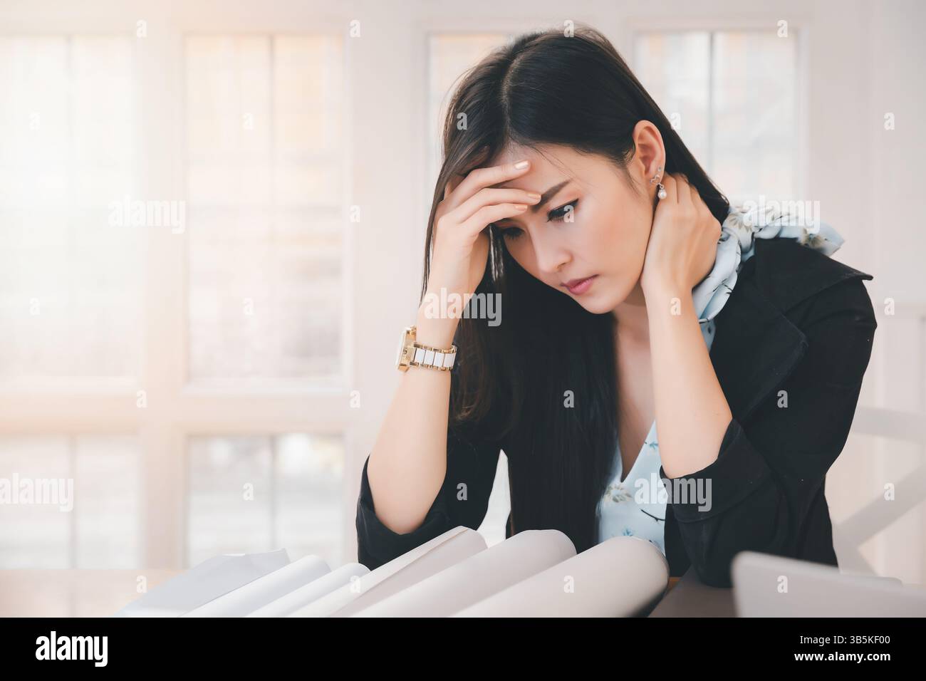 Young asian woman architect holding forehead and neck while working on ...