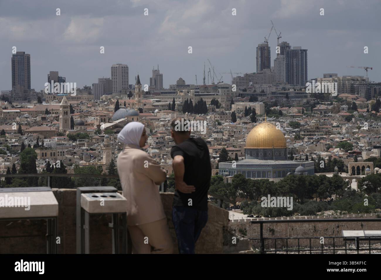 A couple overlooks the Dome of the Rock Mosque in the Al-Aqsa Mosque ...