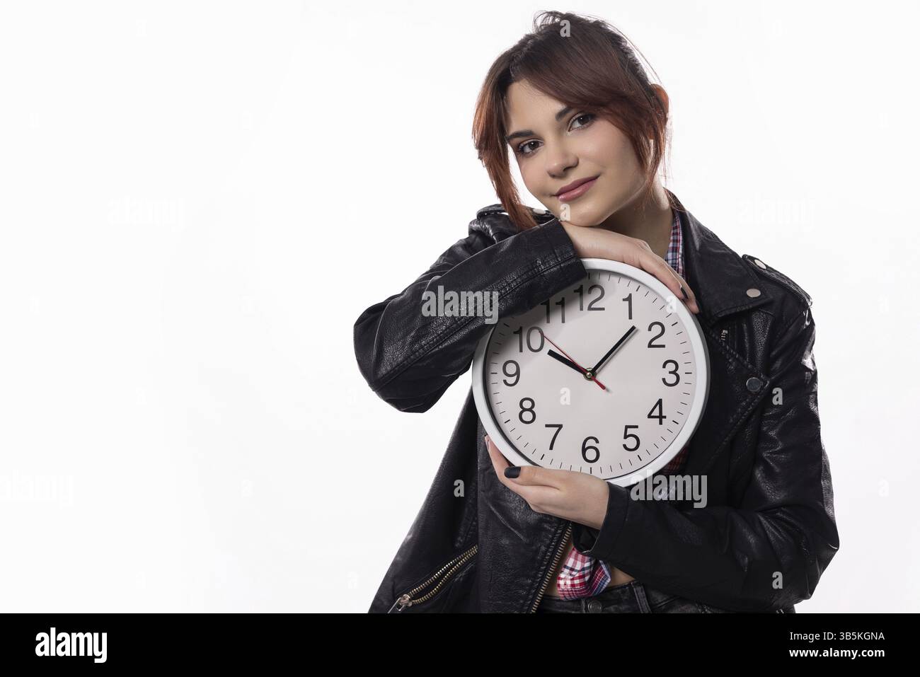 A stylish young woman poses with a clock, symbolizing the importance of ...