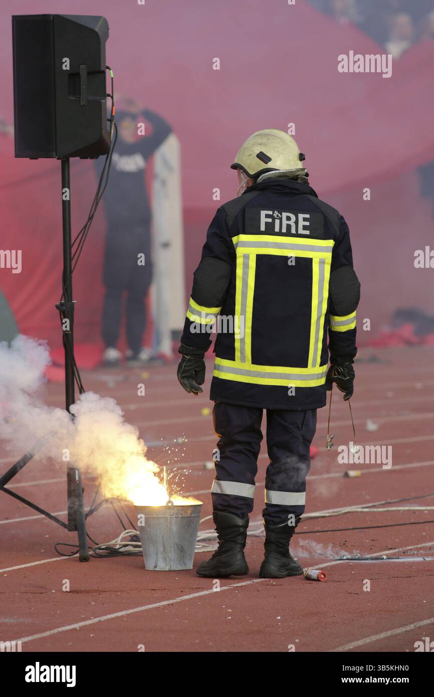 Firefighter putting down football fans' torches fire during a match ...