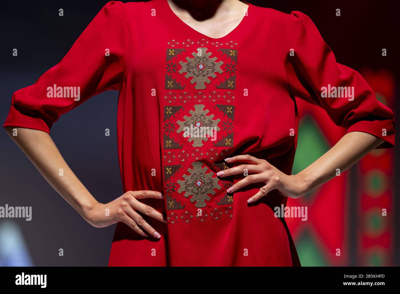 A female model presents a creation during a Fashion week. Red dress ...
