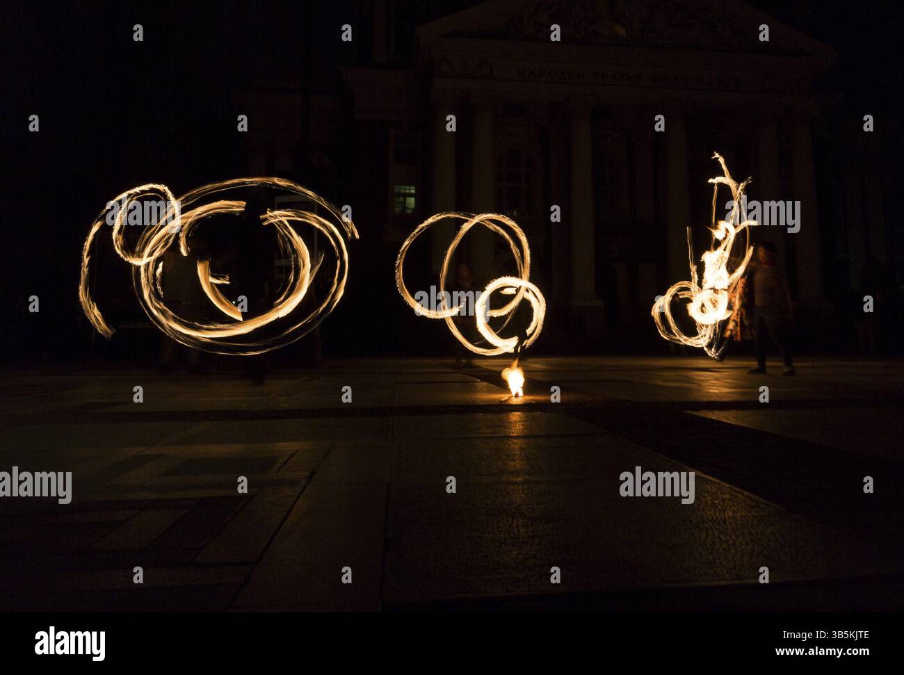 Long exposure image of an art performer at a fire show in the dark ...