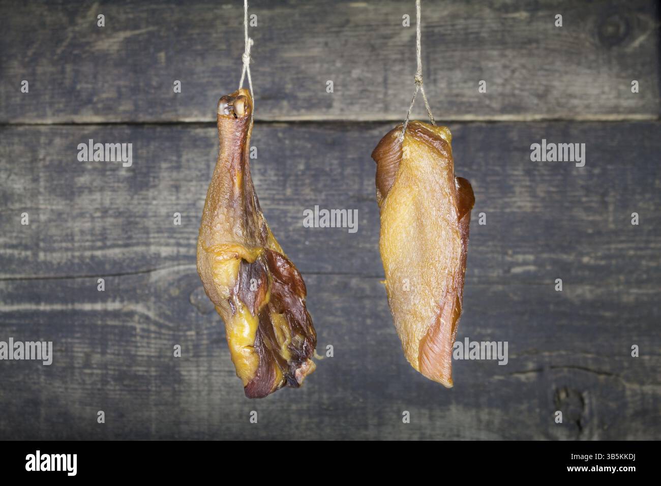 Smoked Chicken Meat Hanging on the Rope Against Wooden Background Stock ...