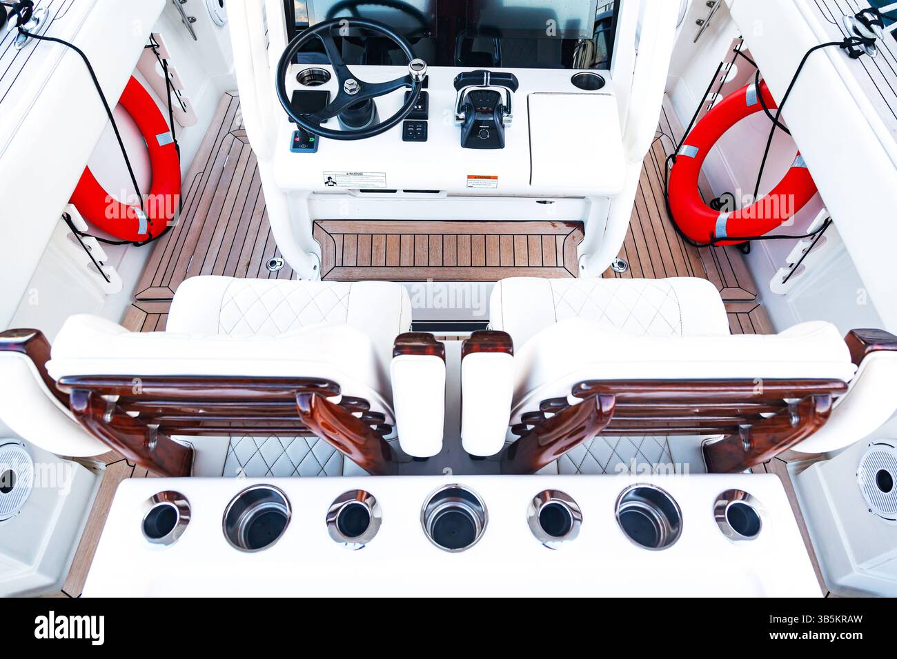 Luxurious boat control cabin with white leather seats, steering wheel ...