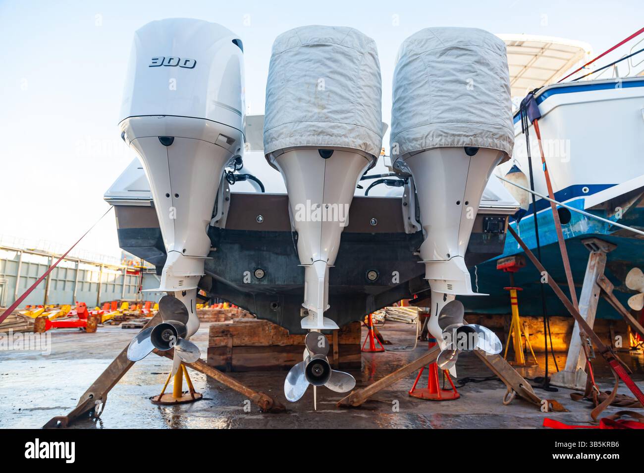 Three outboard motors mounted on a transom mount at the stern of the ...