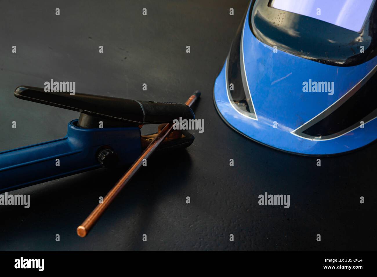 Graphite gouging electrodes with holder and welding mask on black ...