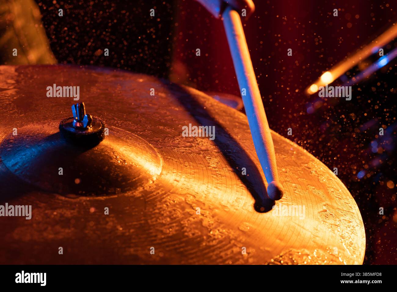 Drum sticks hitting snare drum with splashing water on dark background ...