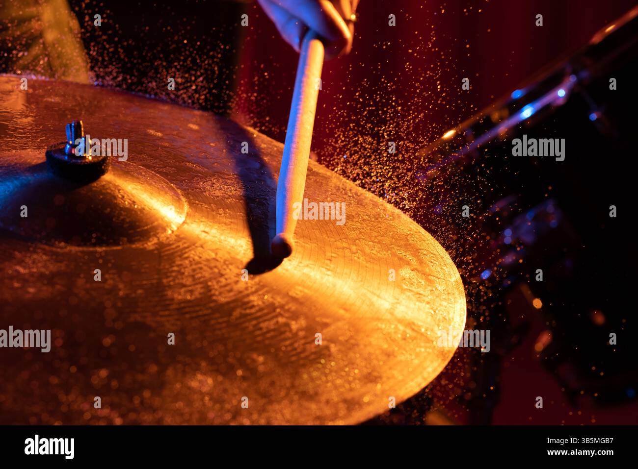 Drum sticks hitting snare drum with splashing water on dark background ...