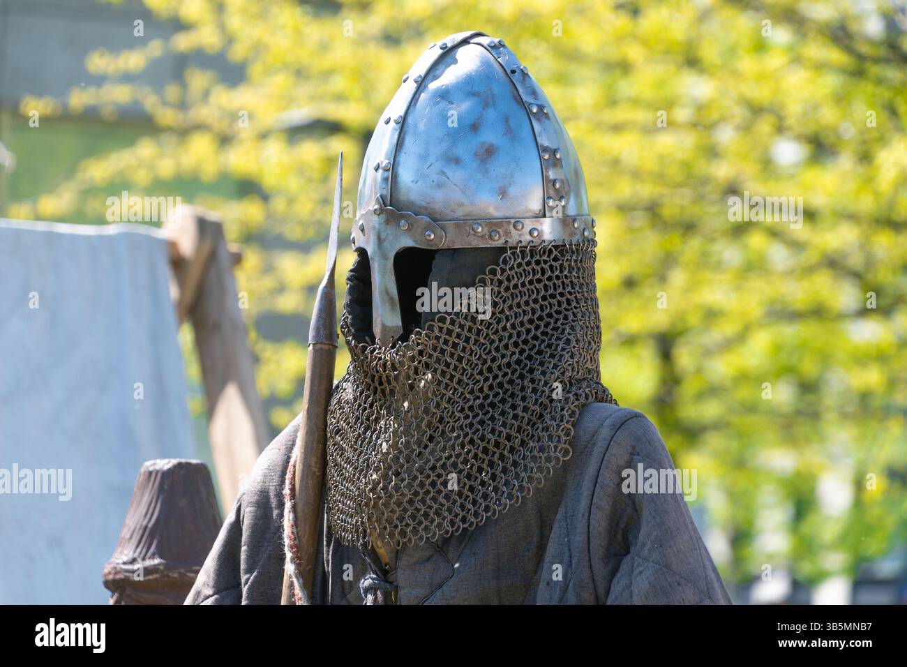 Medieval knight in chainmail and helmet holding spear outdoors in ...