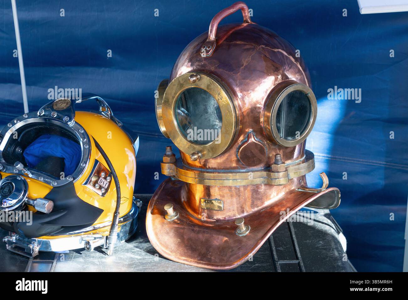 Vintage copper diving helmet with modern diving equipment in nautical ...