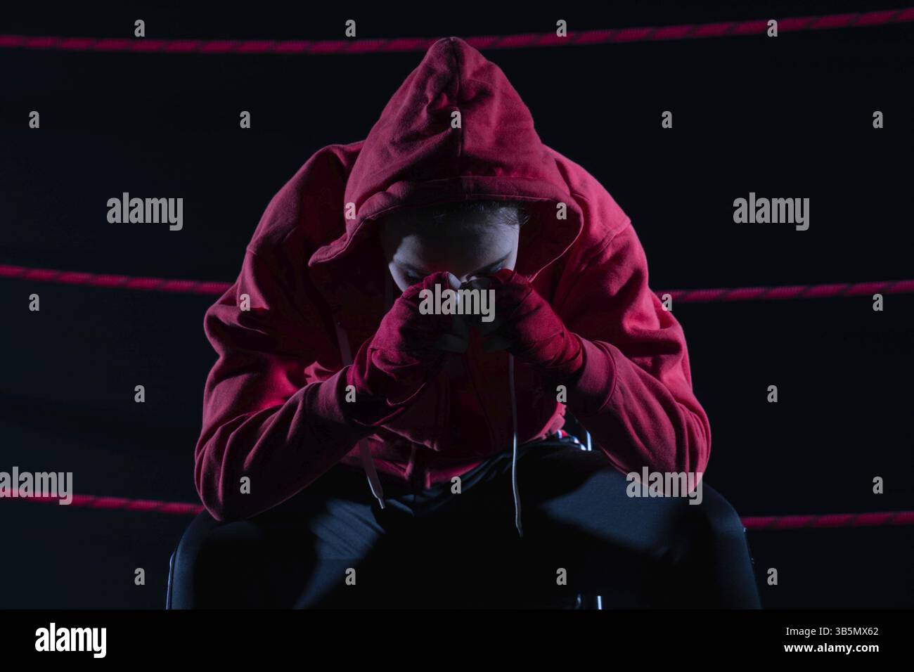 The athlete sits in a chair in the boxing ring after losing the fight ...