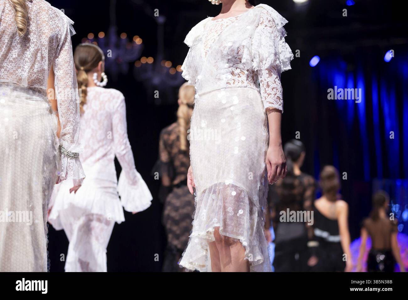 Female models walk the runway in different white dresses during a ...