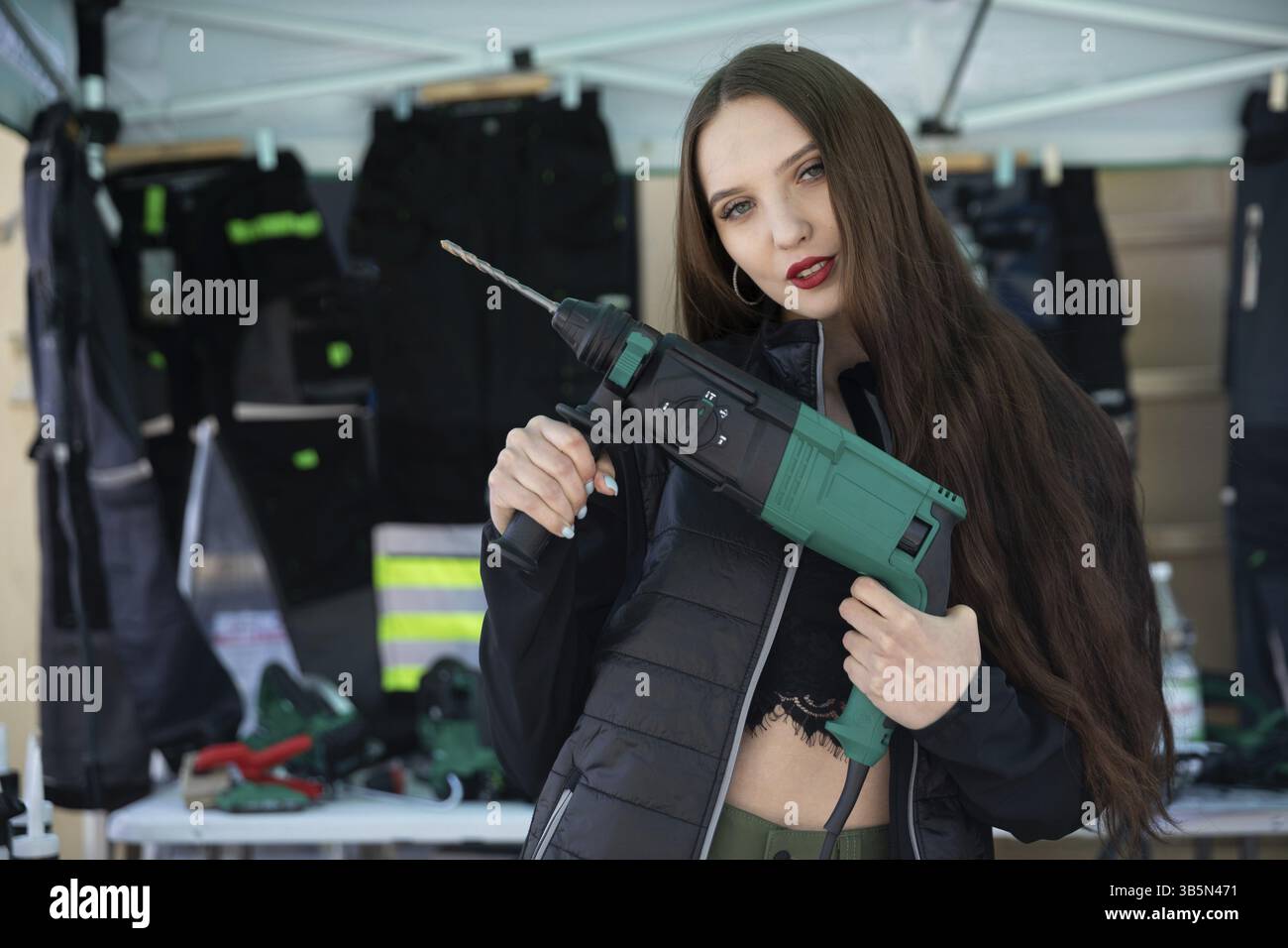 A confident woman skillfully showcasing a powerful tool while dressed ...