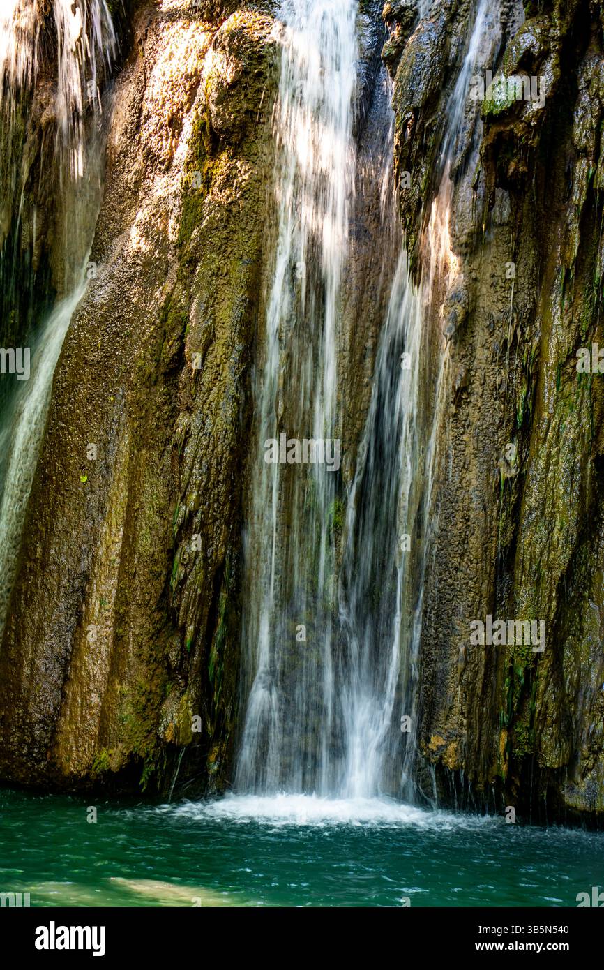 A breathtaking waterfall flows gracefully into a tranquil pool ...