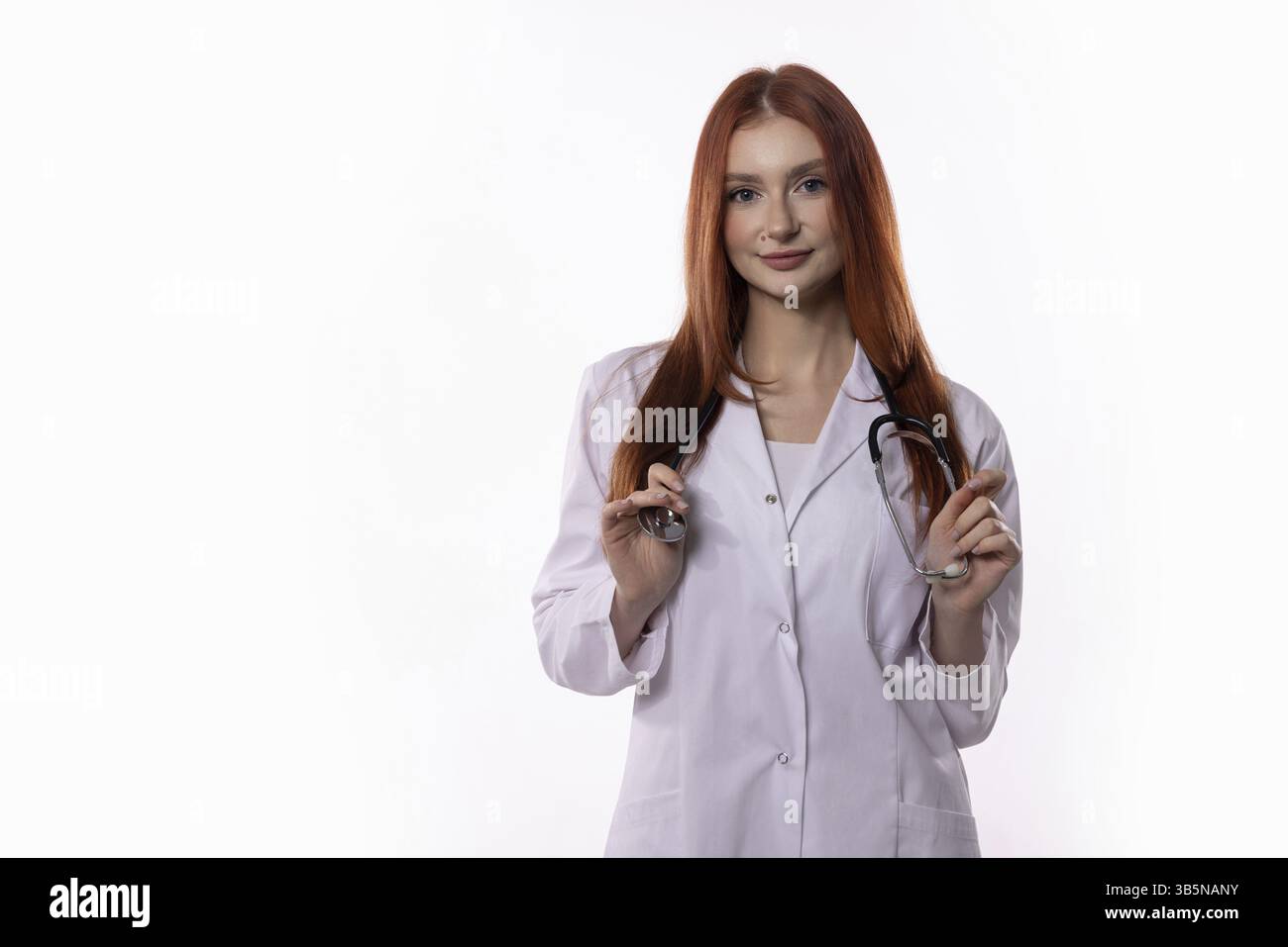 A confident young female doctor wearing a lab coat with a stethoscope ...