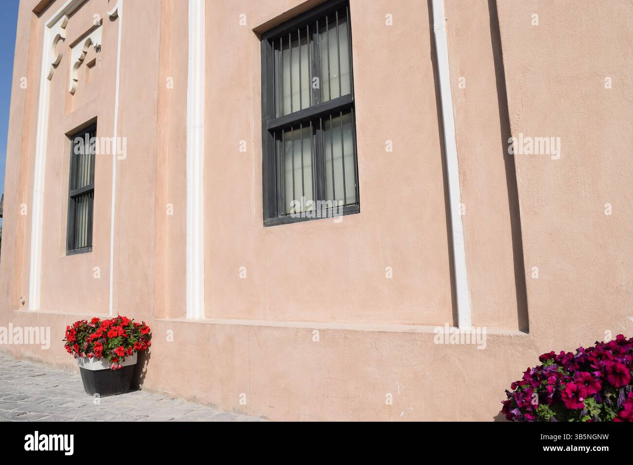 Mediterranean charm: Peach-colored building facade adorned with vibrant ...