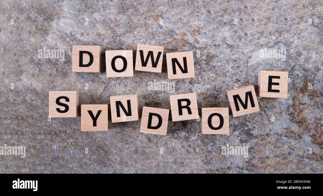 wooden blocks building the word down syndrome, rough stone as ...