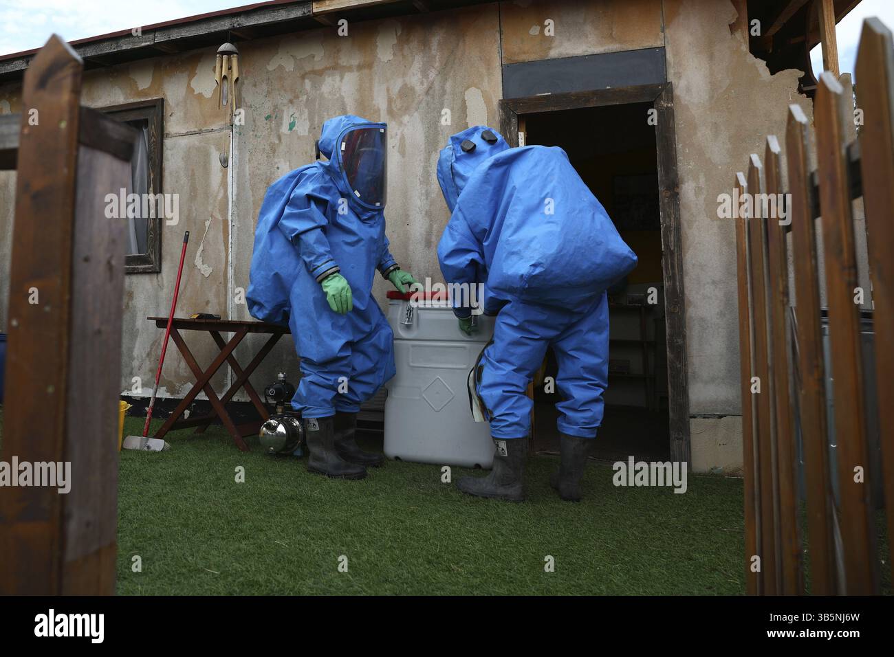 People wear blue Personal protective equipment (PPE) with gas mask for ...
