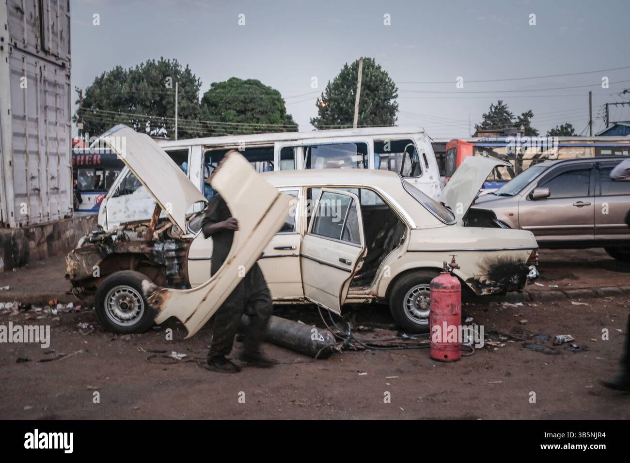 May 14, 2022, NAIROBI, KENYA: A mechanic carrying parts of a damaged ...
