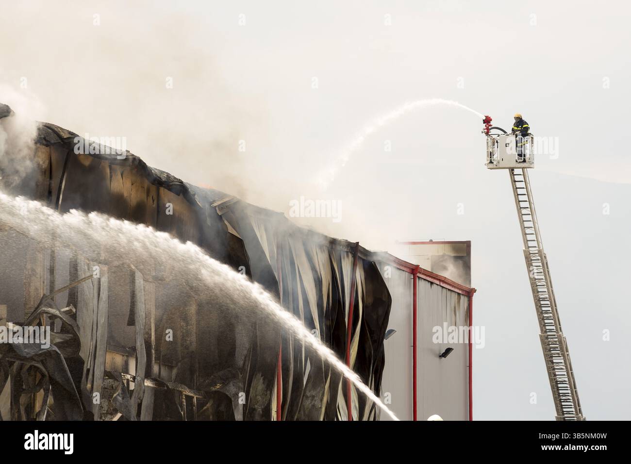 Fire disaster in a warehouse. Fire fighting in an industrial area Stock ...