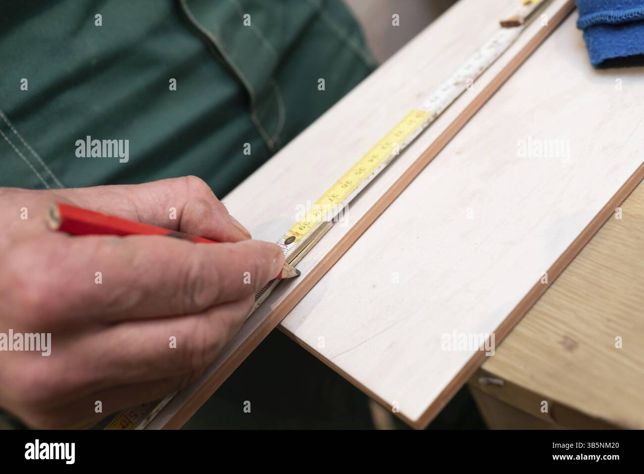 The builder measures the distance on the ceramic tile using a measuring ...