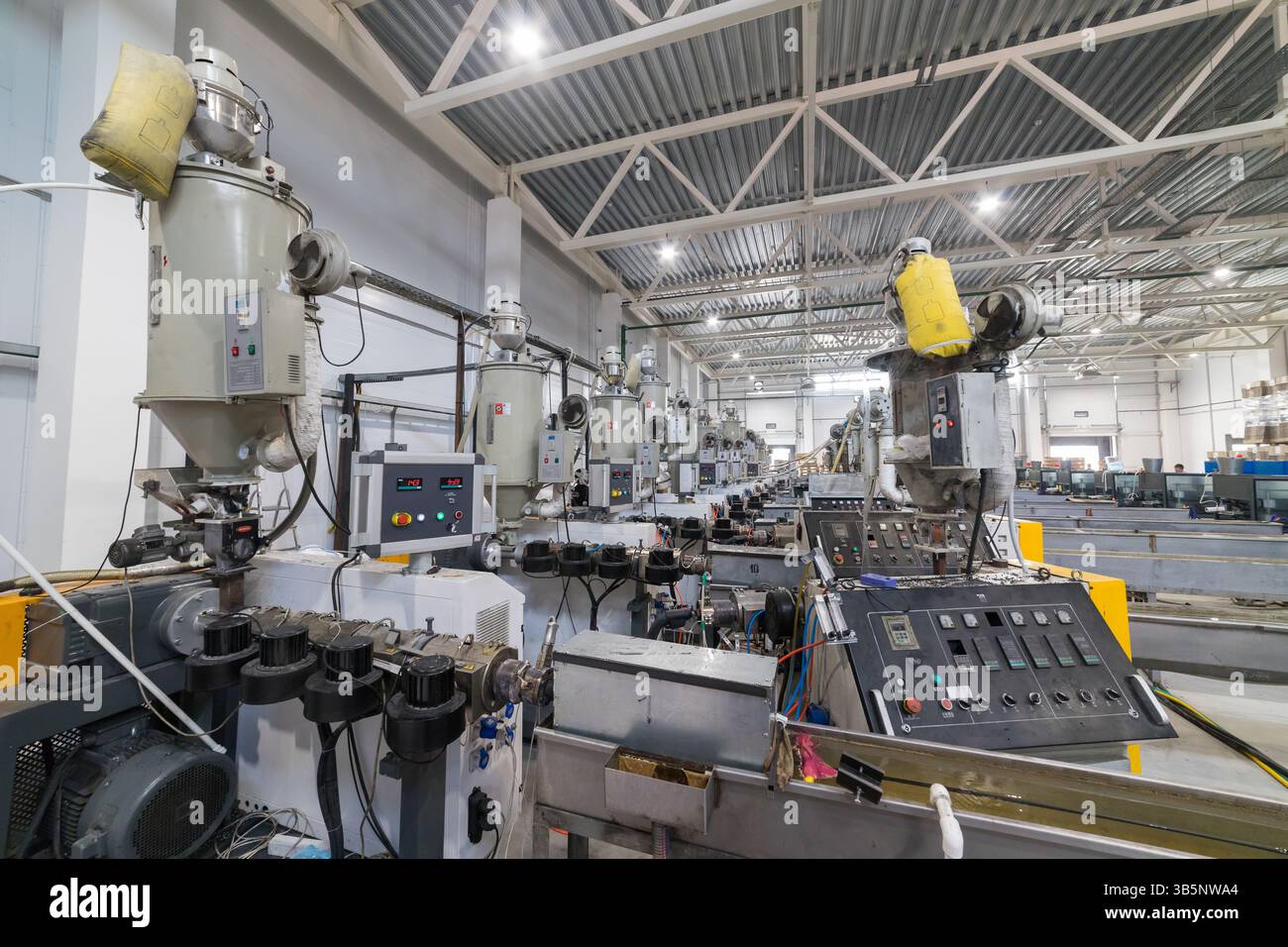 Extrusion machines processing plastic granules in factory Stock Photo ...