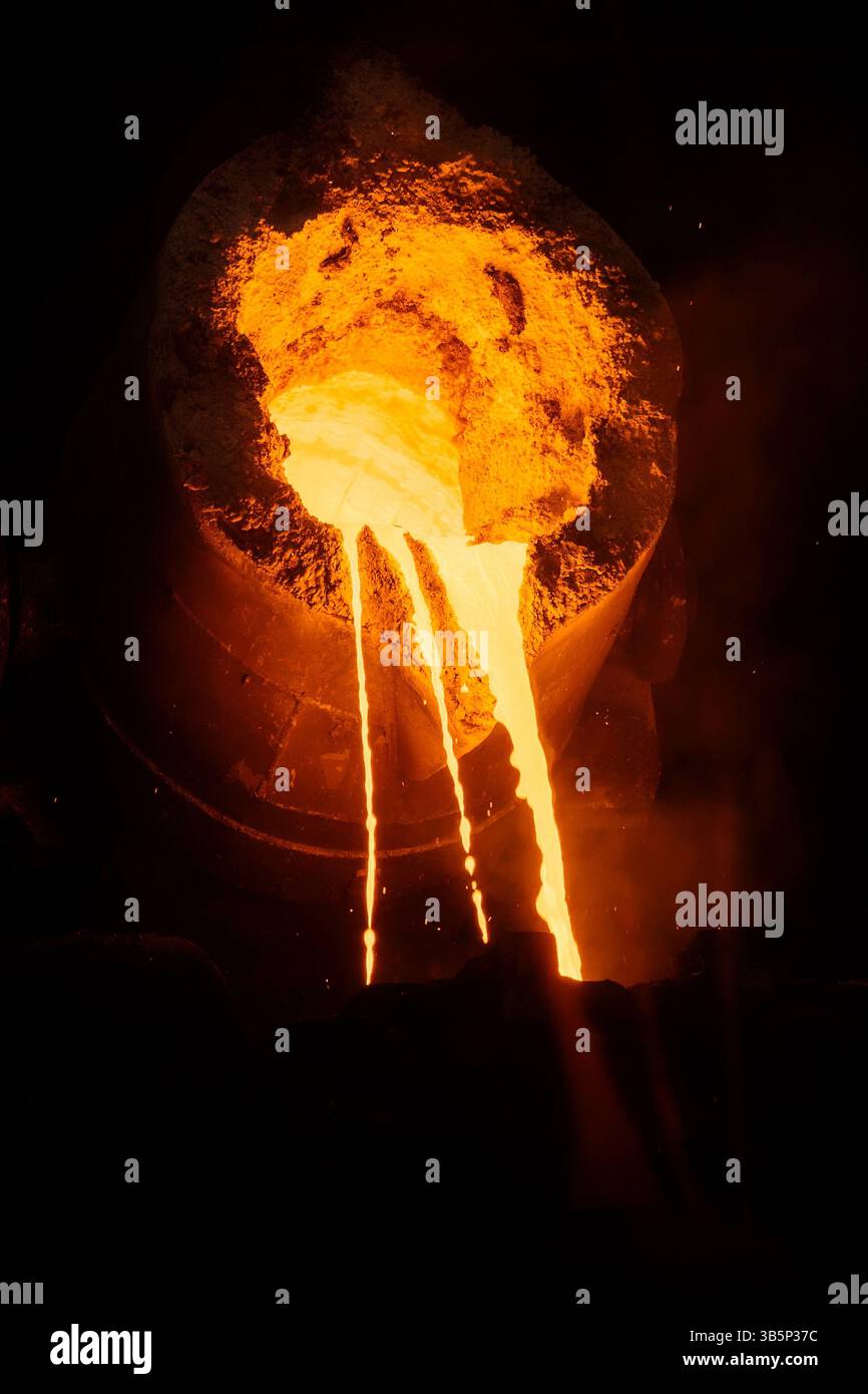 Metal casting process in metallurgical plant, molten metal is pouring ...