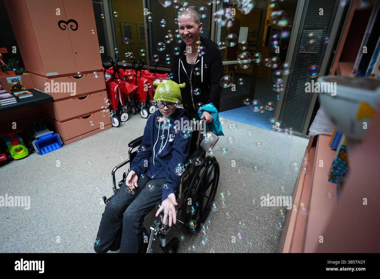 Pediatric patient Emmett Hill, 11, enters an event through bubbles with ...
