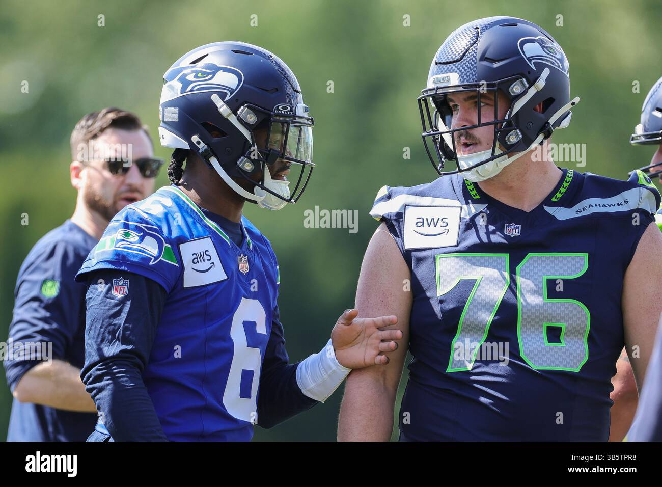 Seattle Seahawks quarterback Jalen Milroe, left, speaks with guard Grey ...
