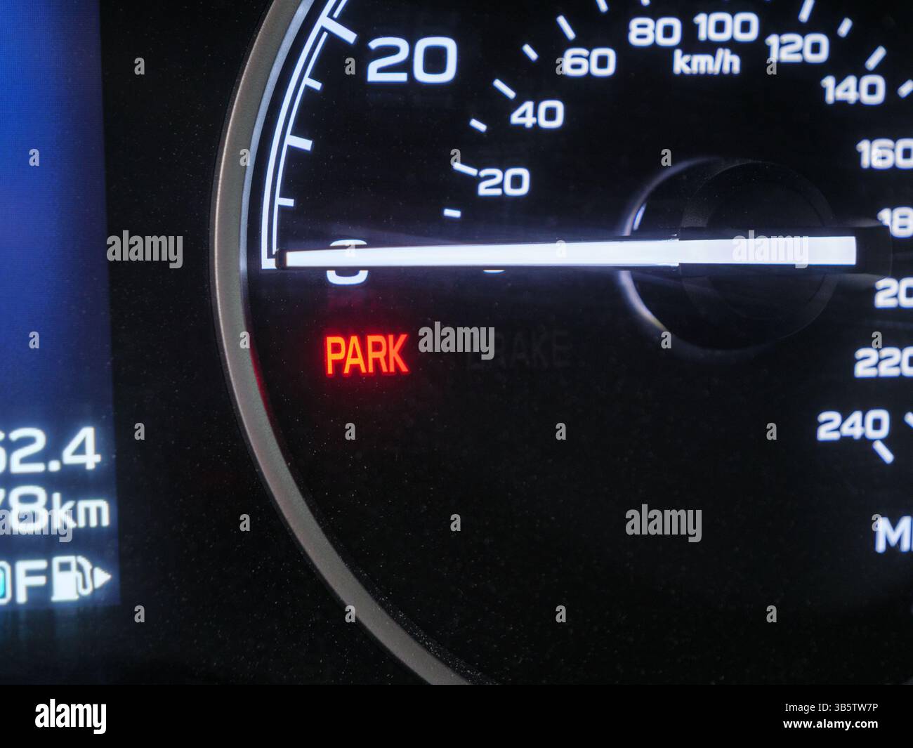 Automotive dashboard closeup revealing glowing parking brake warning ...
