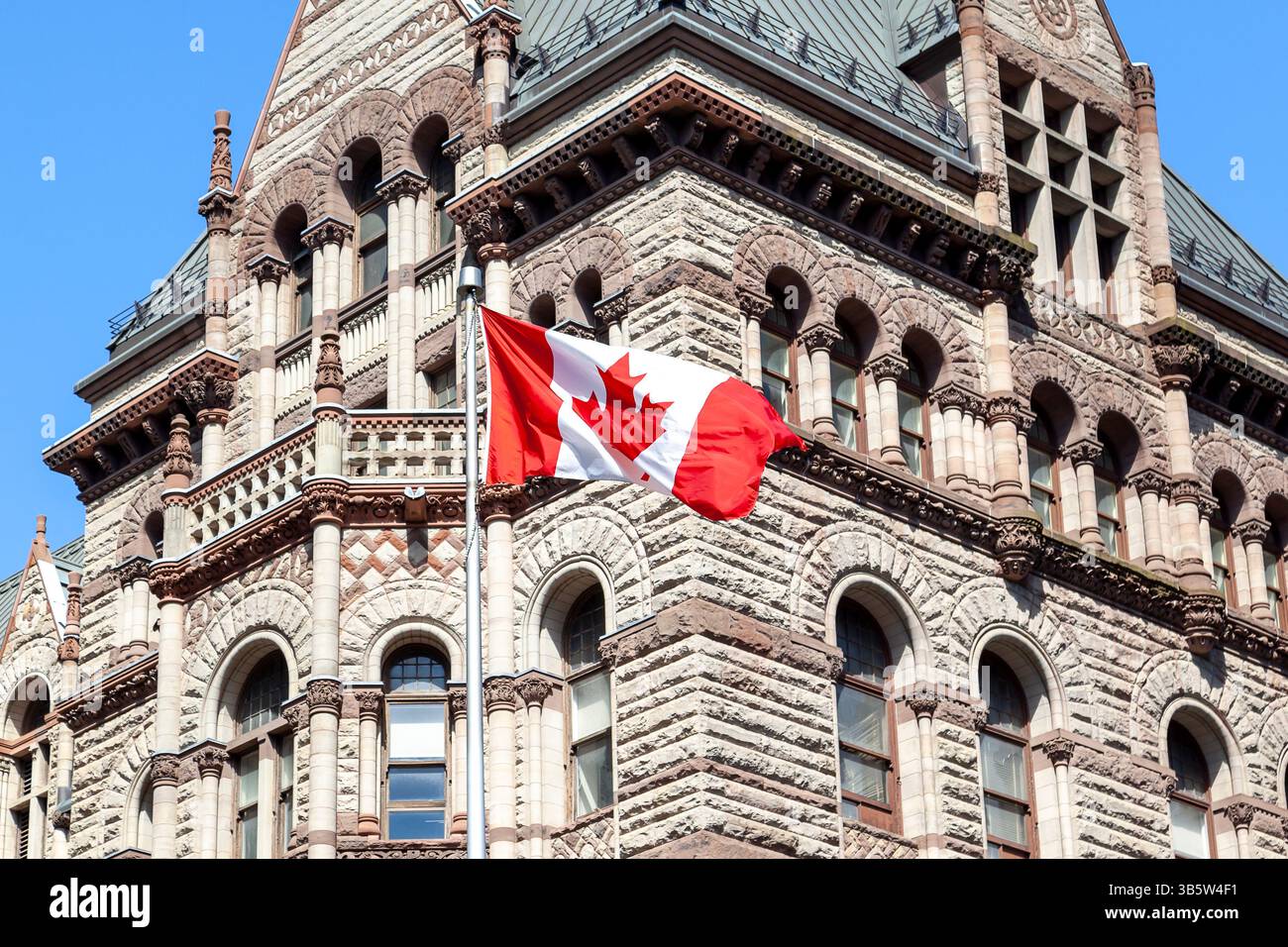 The waving Canadian flag with Old City Hall in background in Toronto ...