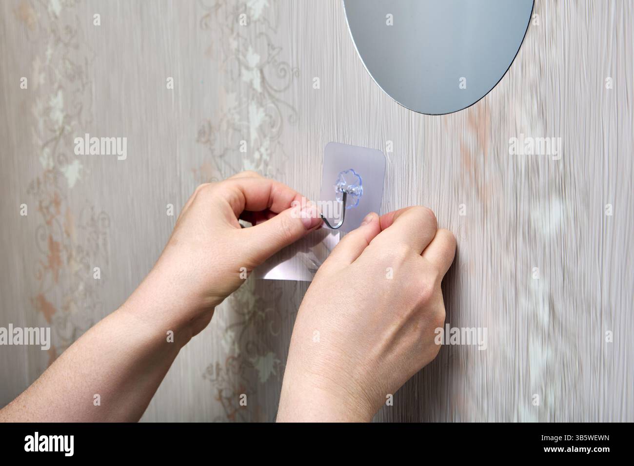Person presses nano gel hook onto wall surface ensuring strong hold and ...