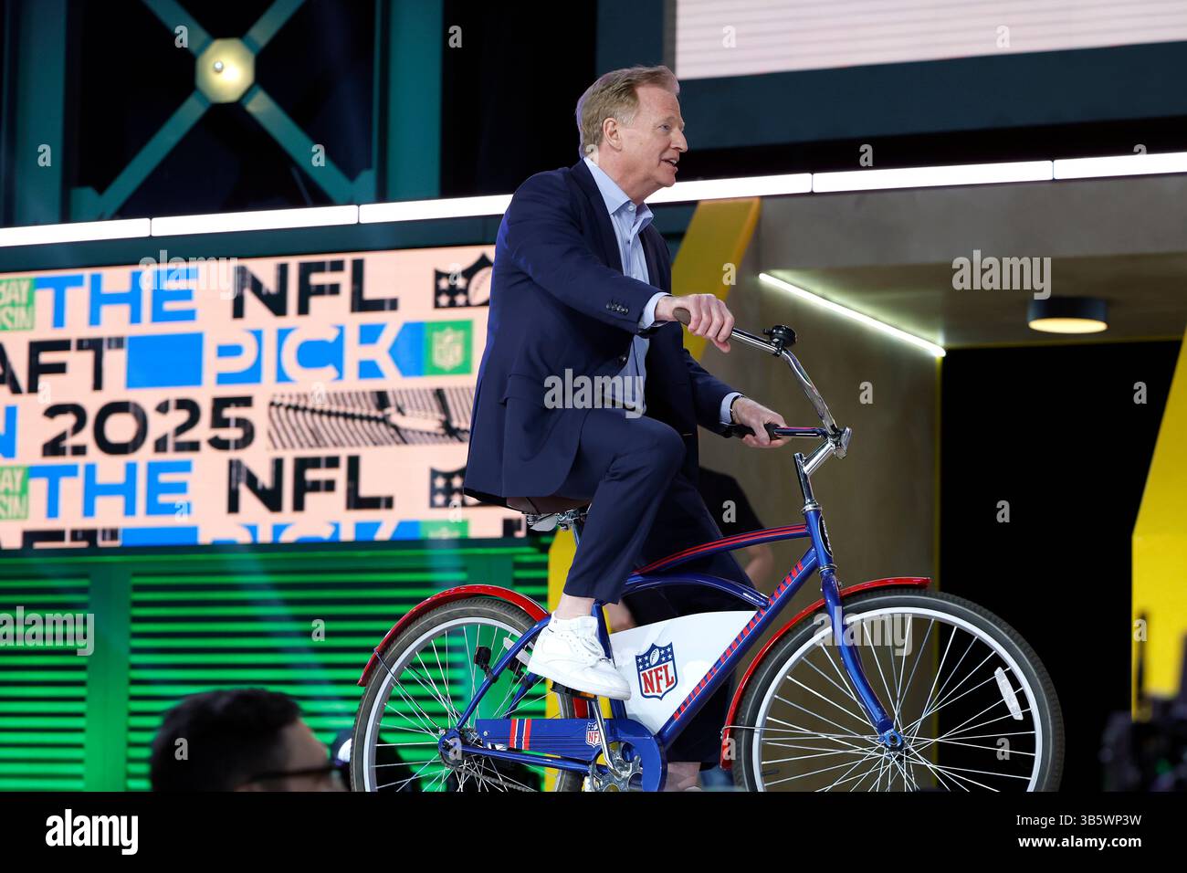 NFL Commissioner Roger Goodell rides a bike on stage before the first round of the NFL football ...