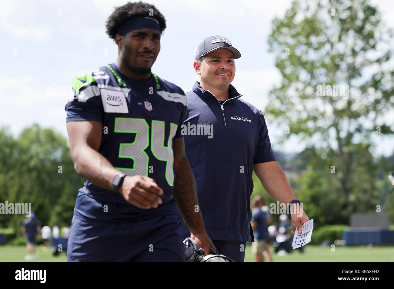 Seattle Seahawks head coach Mike Macdonald, right, walks off the field ...