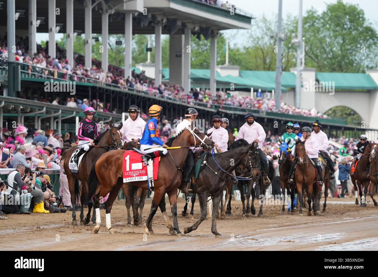 Horses are led onto the track to move into the starting gate before the ...