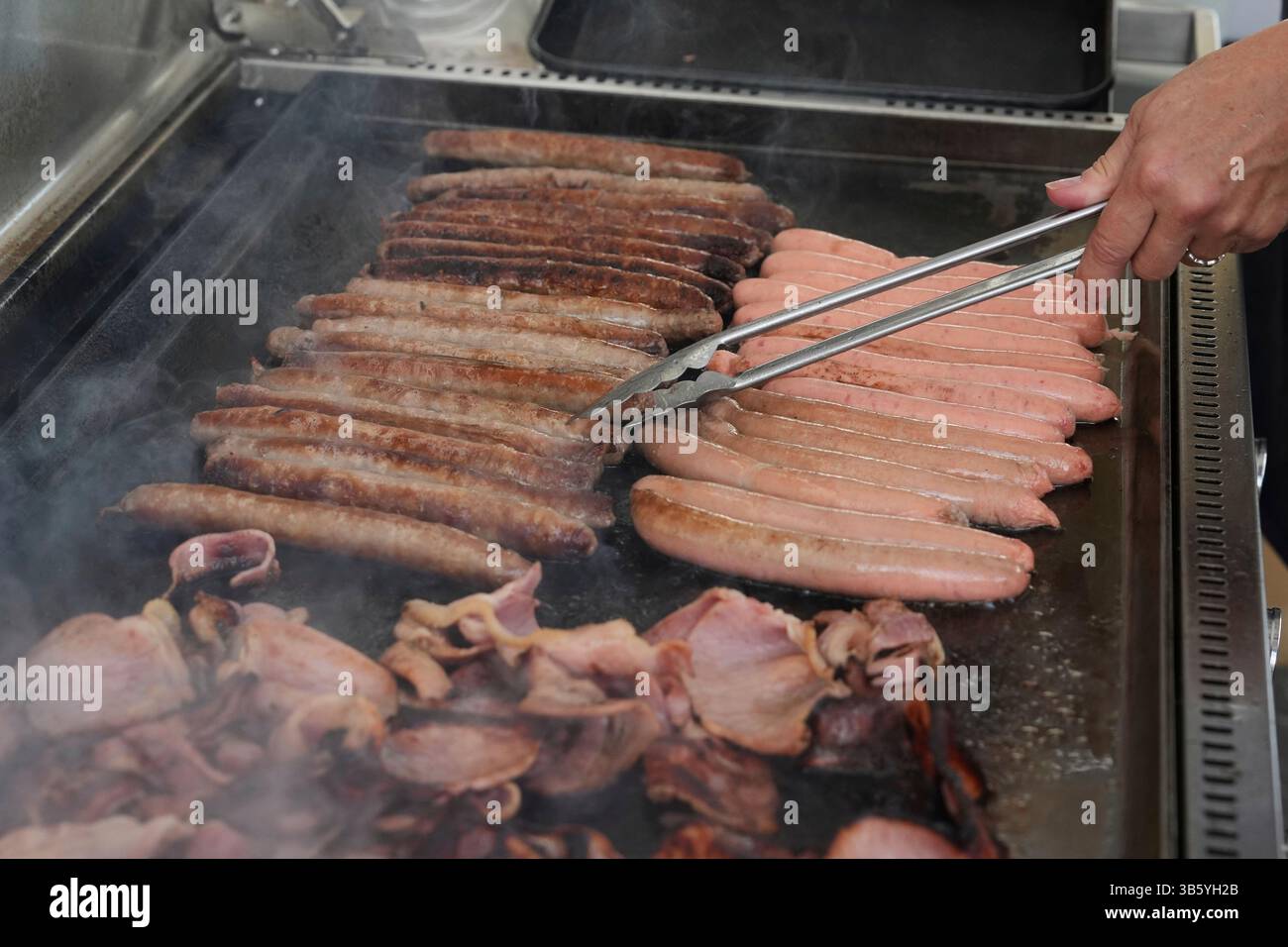 A volunteer cooks sausages on a BBQ outside a polling booth at Sydney's ...