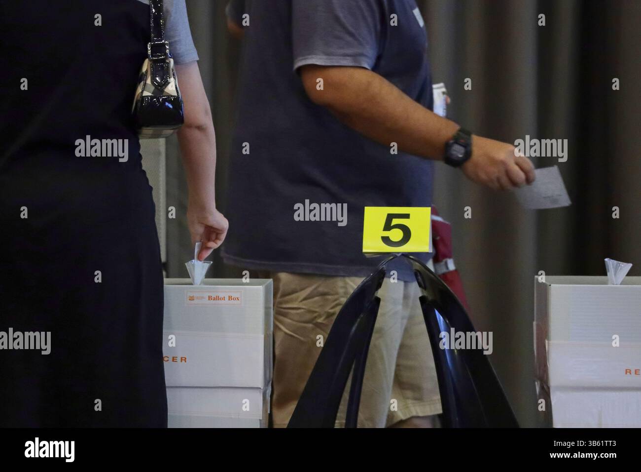 A resident drops a voting slip into the ballot box at a polling station ...