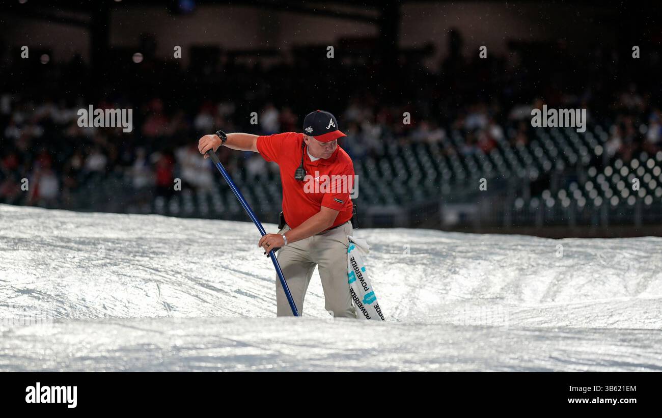 Grounds crew work during a rain delay in the ninth inning of a baseball ...