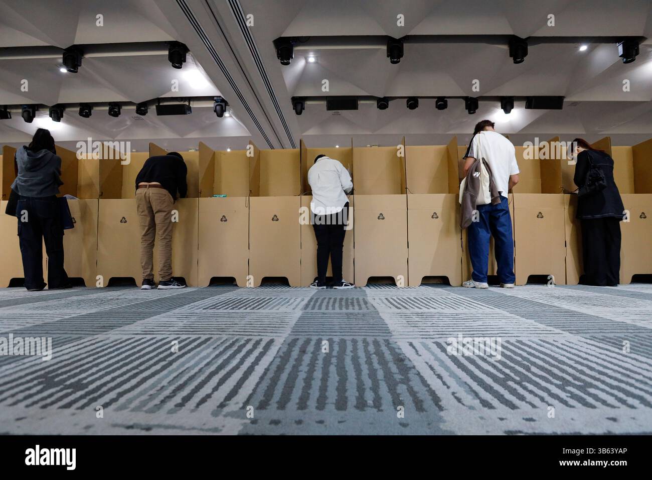 Voters mark their ballot papers in private booths on election day ...