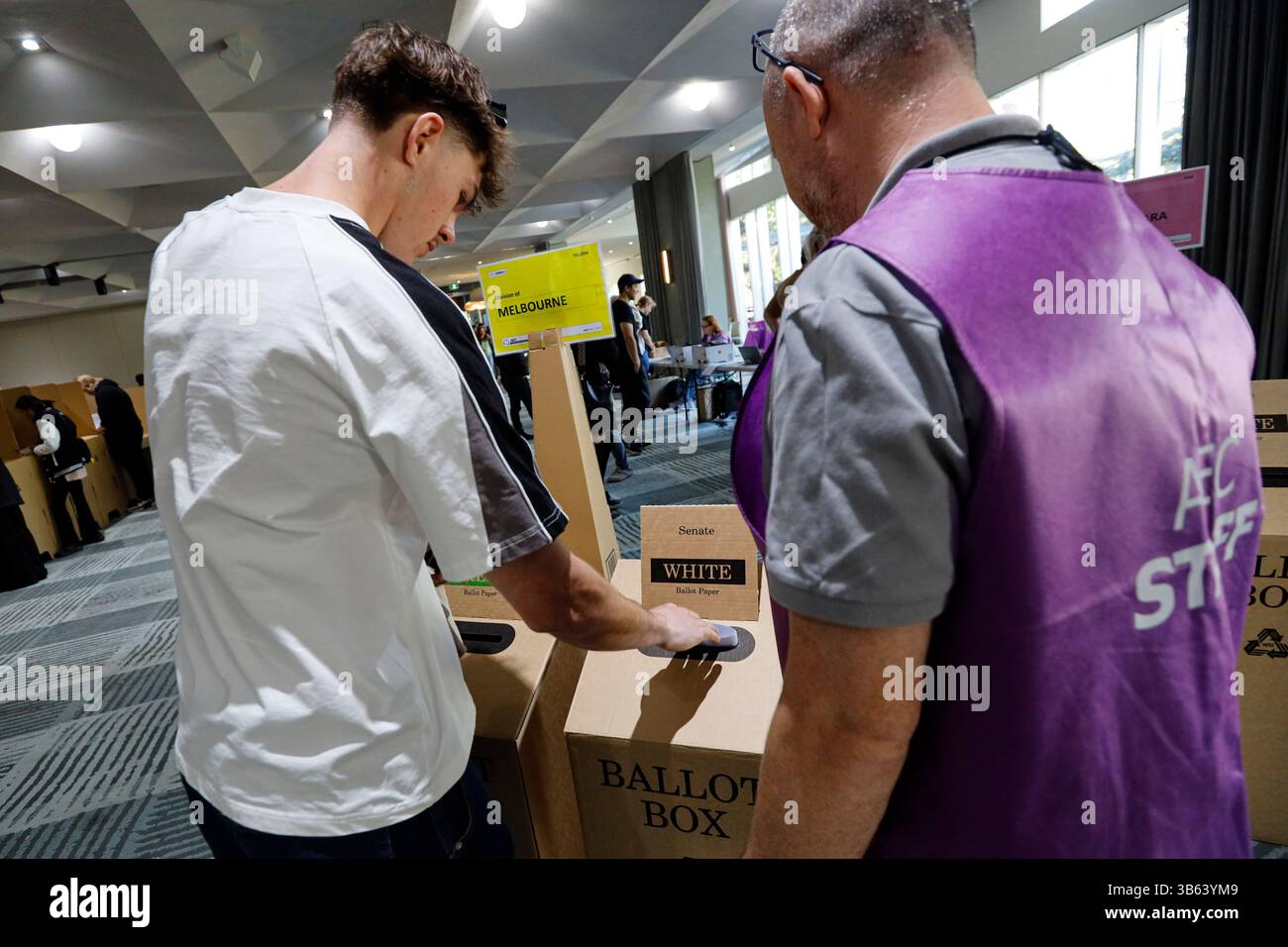 A voter places their ballot into a box at a polling centre on election ...