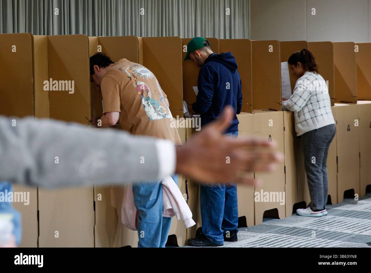 Voters mark their ballot papers in private booths on election day ...