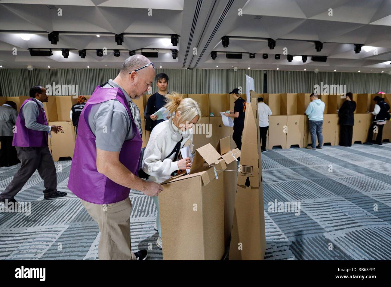 A voter places their ballot into a box at a polling centre on election ...