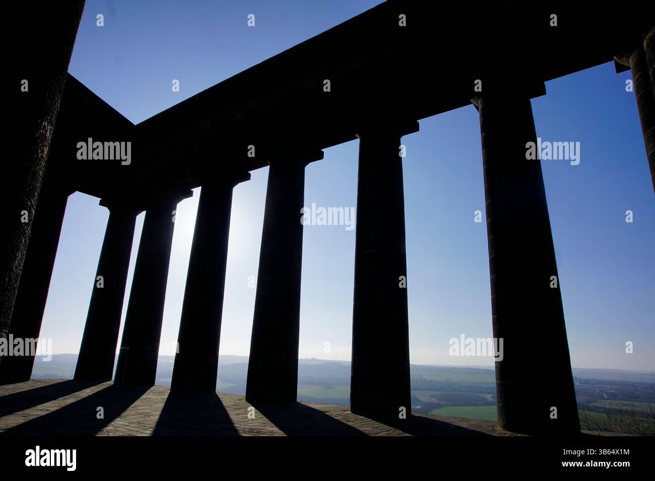Ancient Stone Structure with Tall Columns Under Bright Blue Sky ...