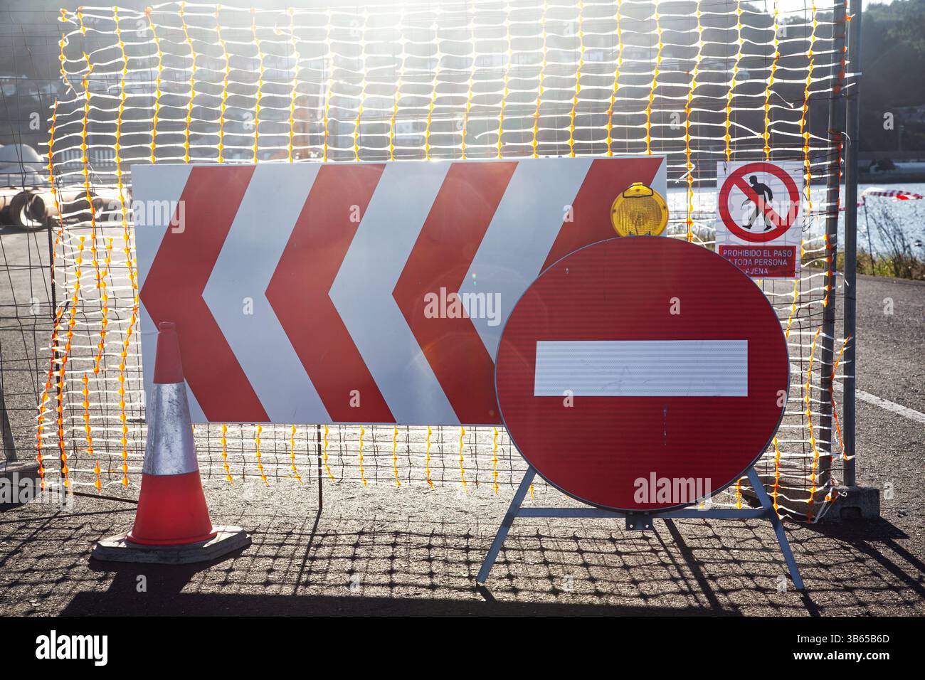 Fencing the road with a mesh fence and road signs and cones for repair ...