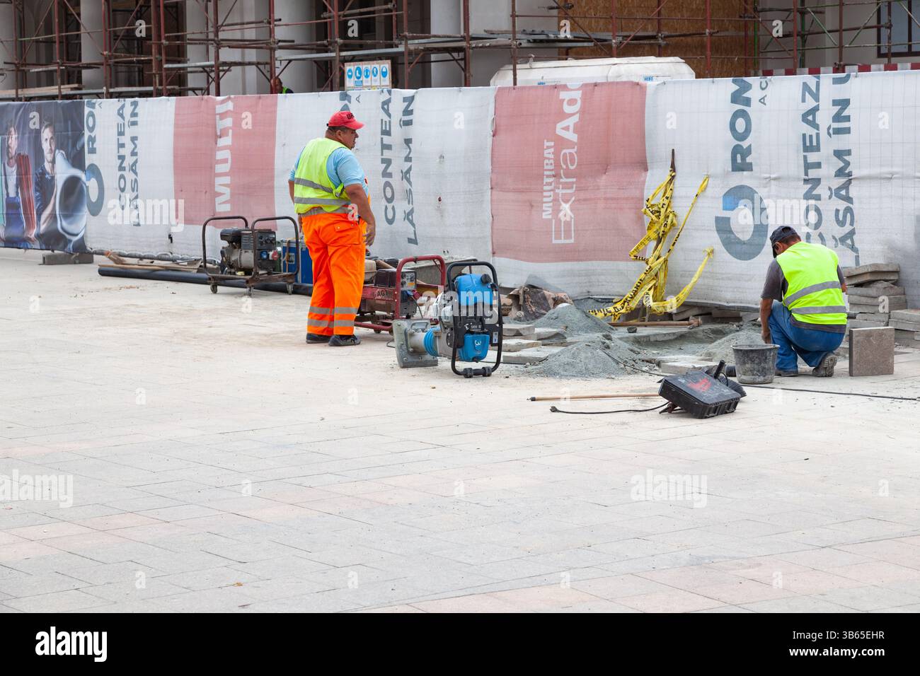 Road repair work involving people, laying new paving slabs Stock Photo ...