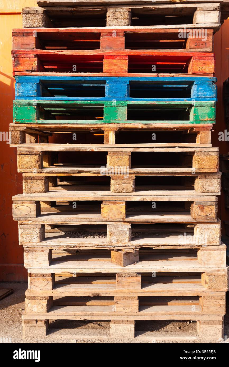 Multi-colored pallets stacked on top of each other Stock Photo - Alamy