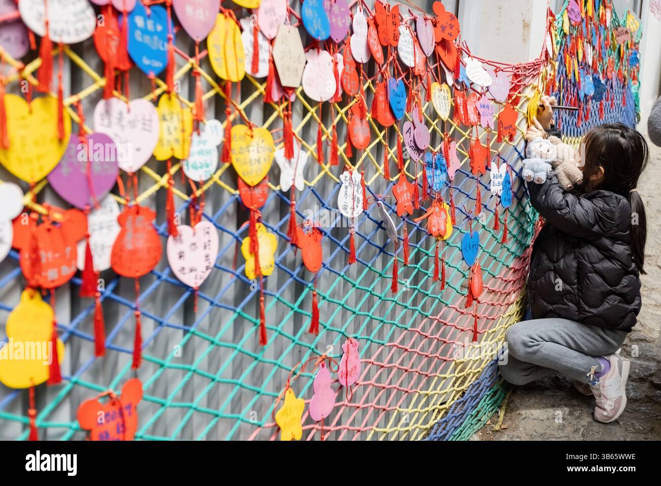Colorful paper wishes and messages hang on a prayer wall in Macau ...