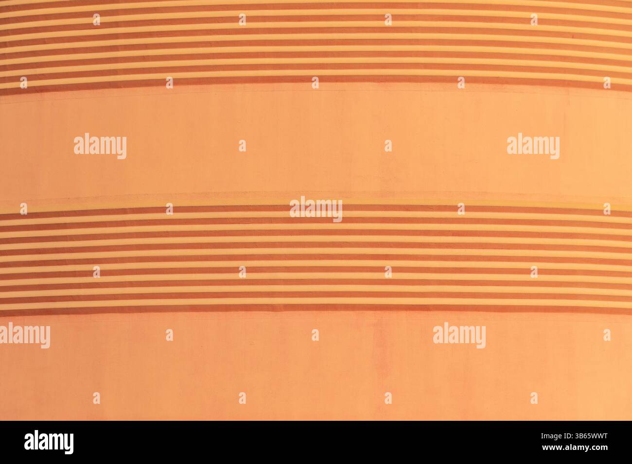 A close-up of a peach-colored wall with evenly spaced horizontal ...