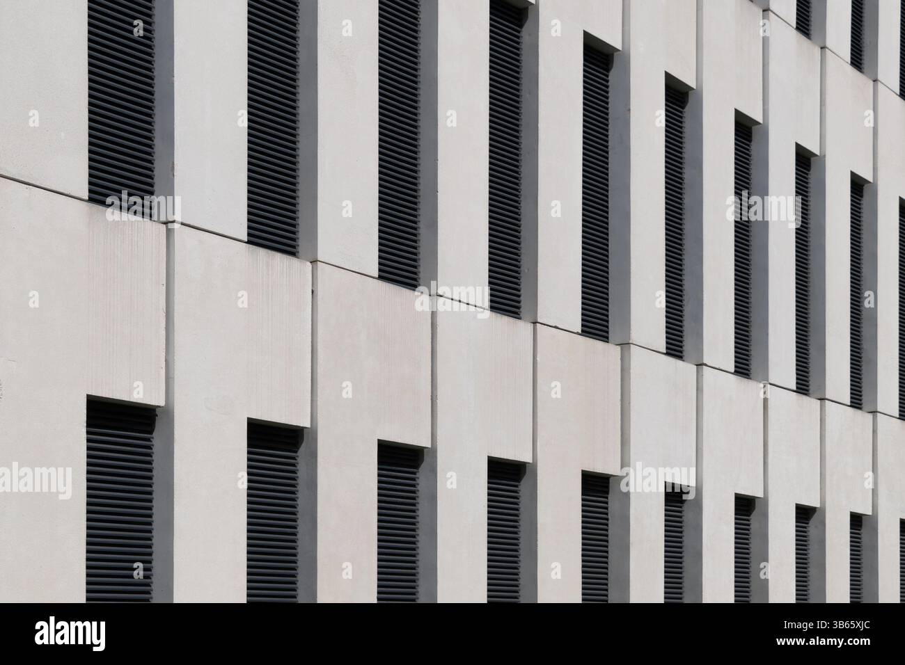 Modern building facade featuring vertical narrow windows set between ...